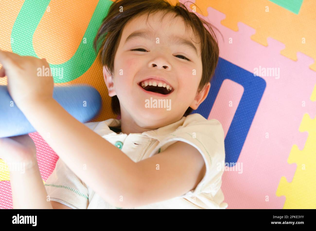 Boy playing on alphabet mat Stock Photo - Alamy