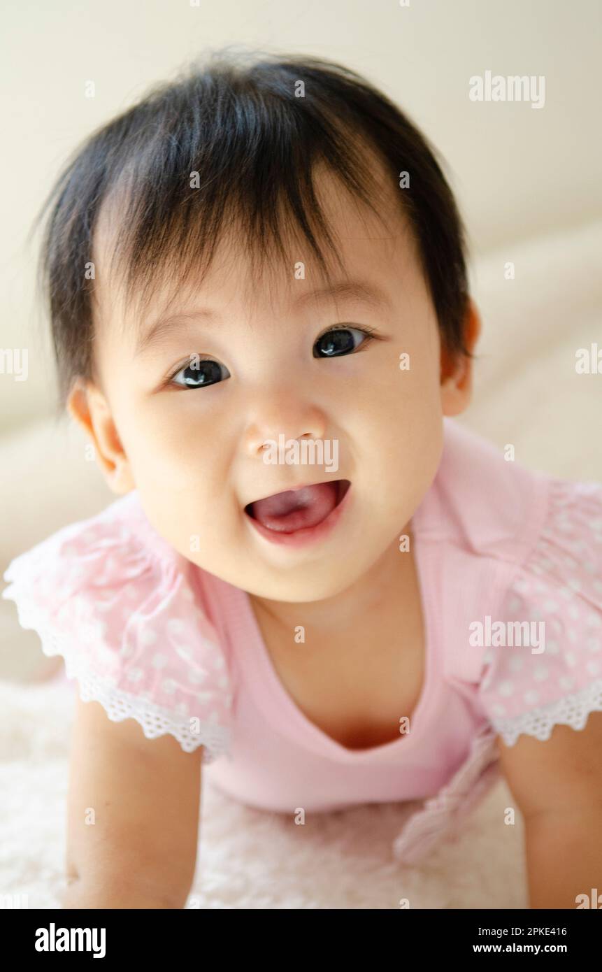 Baby laughing on bed Stock Photo - Alamy