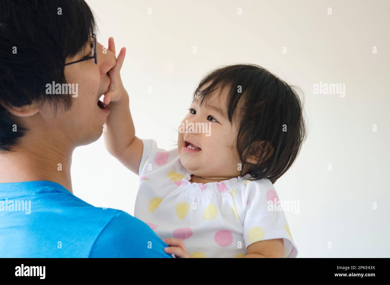 Girl touching father's face Stock Photo - Alamy
