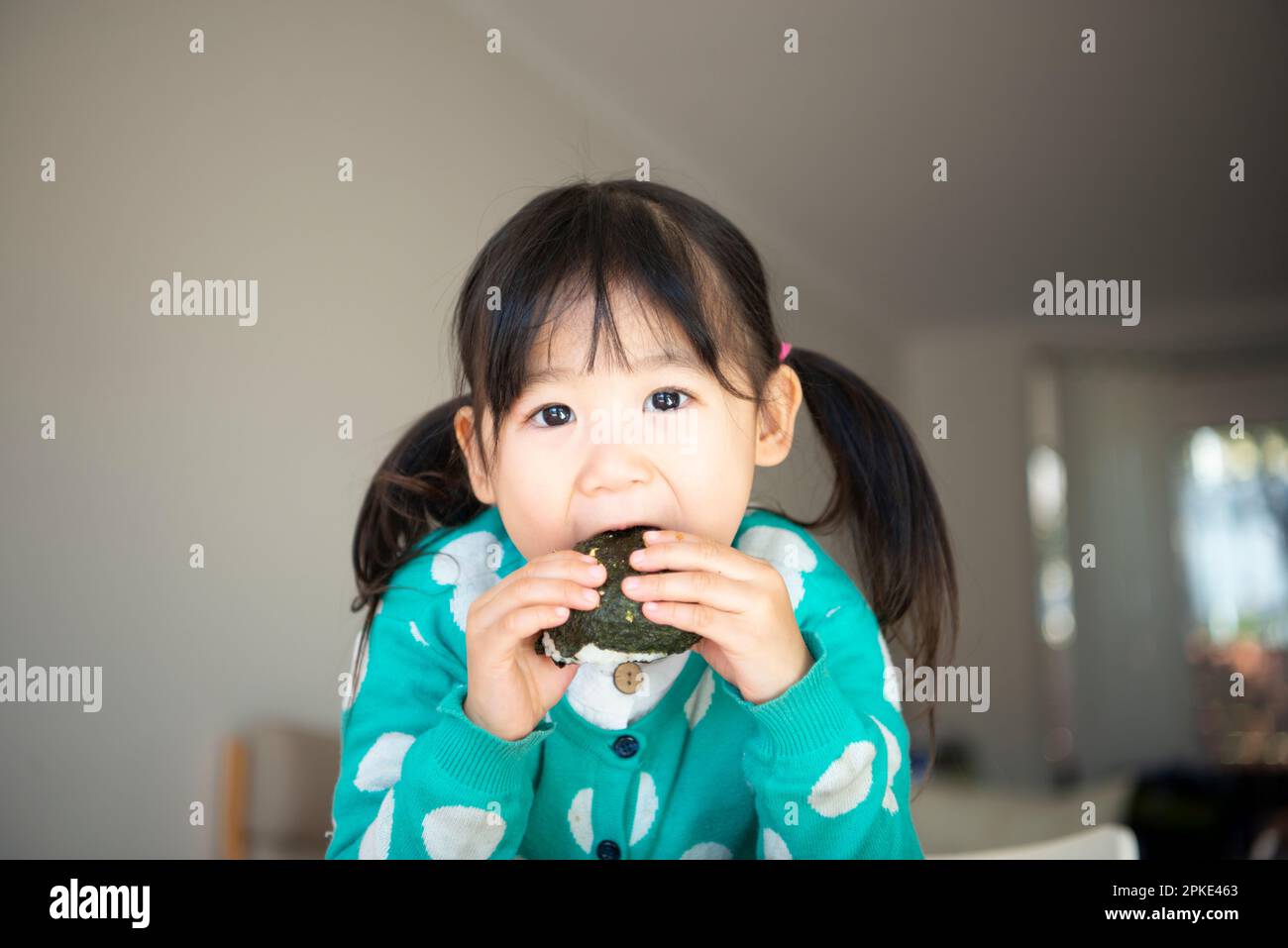 Girl eating onigiri Stock Photo - Alamy