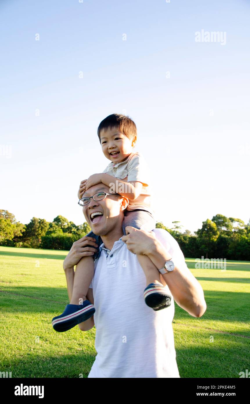 Parent and child laughing while riding on shoulders Stock Photo - Alamy