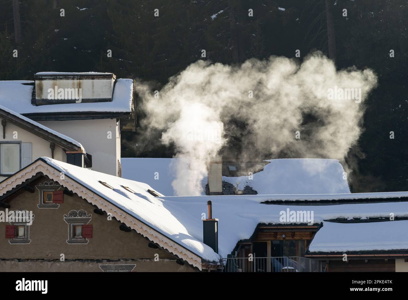 wood smoke comes out of the chimney of a snow-covered house Stock Photo ...
