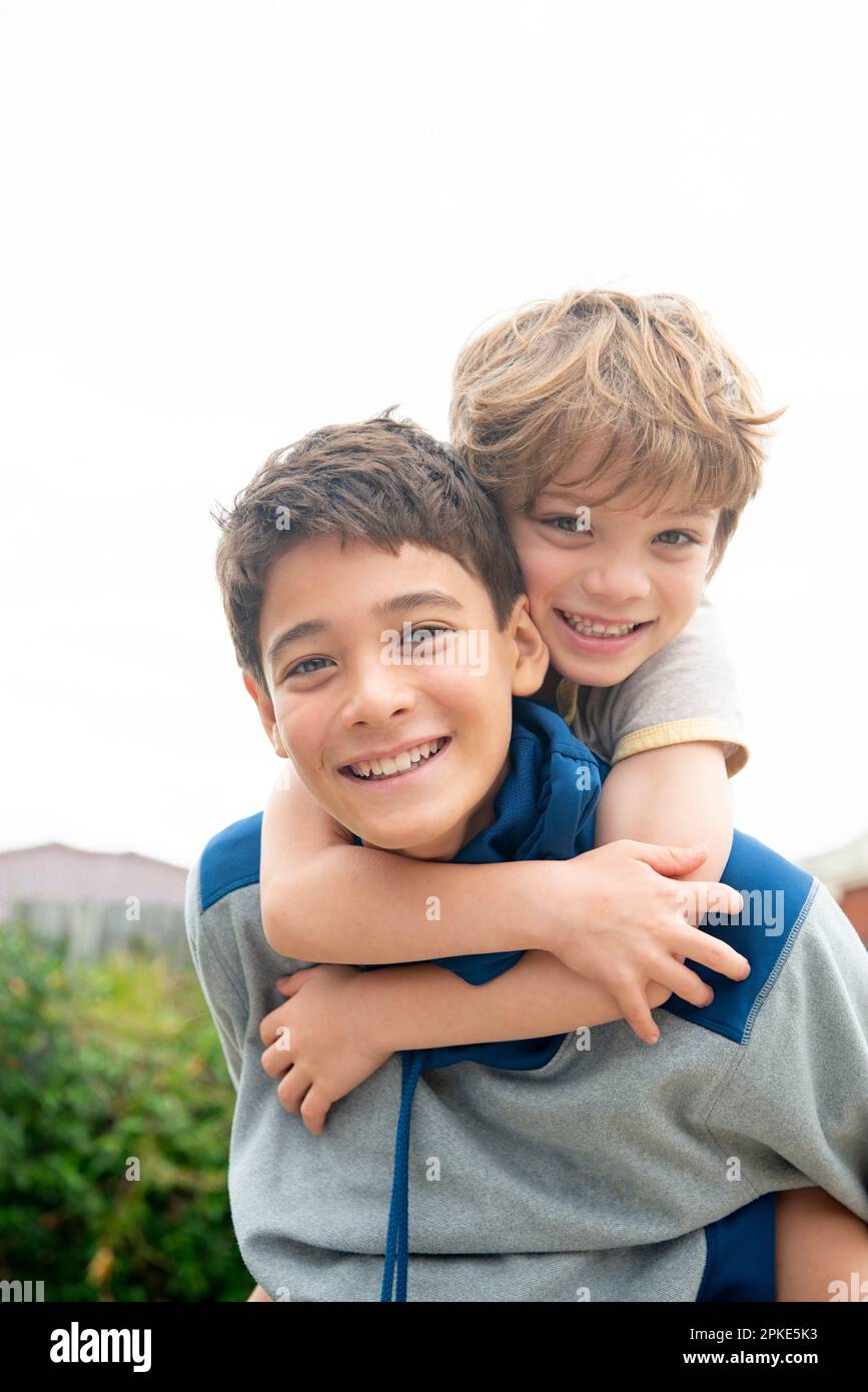 Laughing siblings on piggyback Stock Photo - Alamy