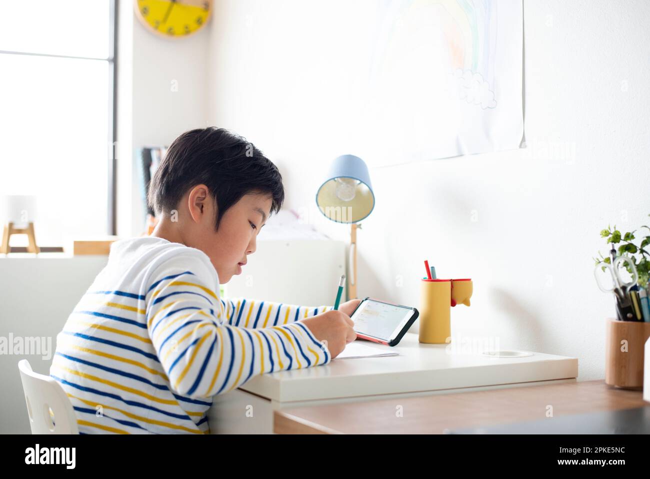 A boy studying with a smart phone in his hand Stock Photo - Alamy