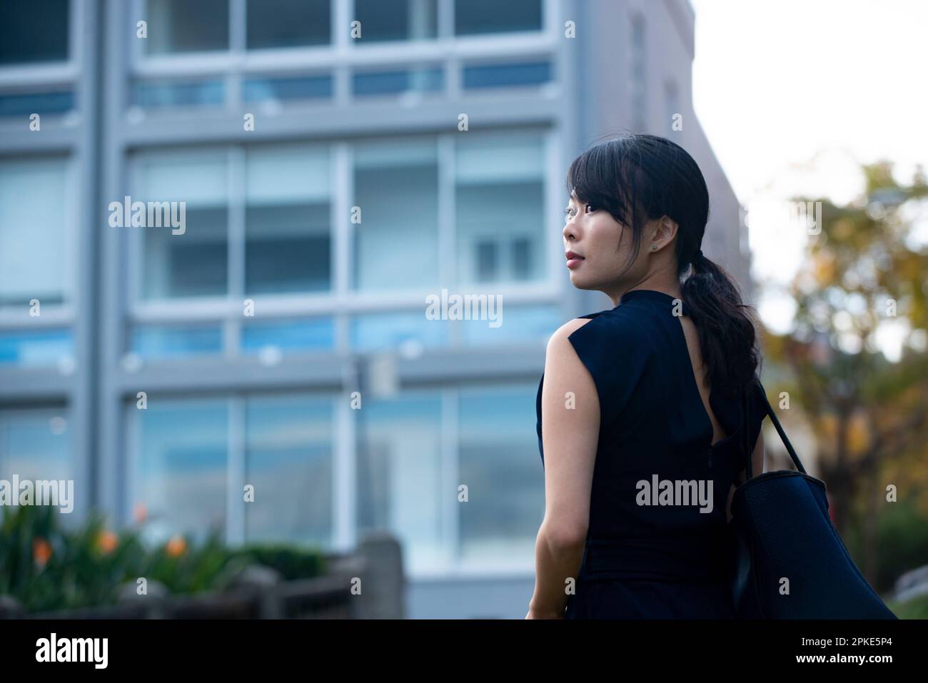 Woman looking back in front of building Stock Photo - Alamy