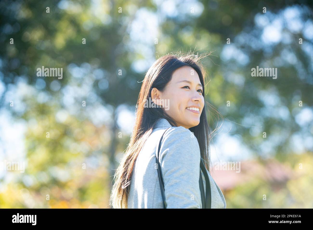 Woman looking back and laughing Stock Photo - Alamy