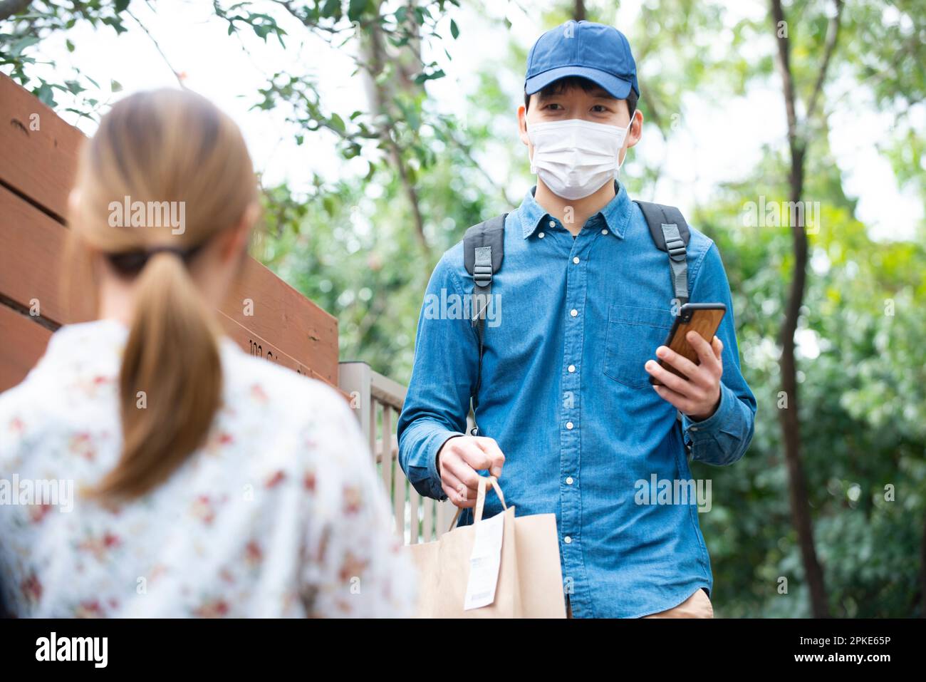 Masked delivery man and woman Stock Photo - Alamy