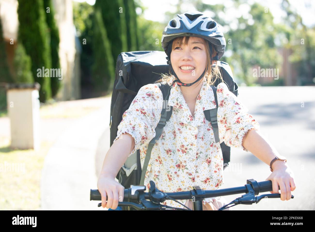 Female delivery man riding on a bicycle while doing food delivery Stock ...