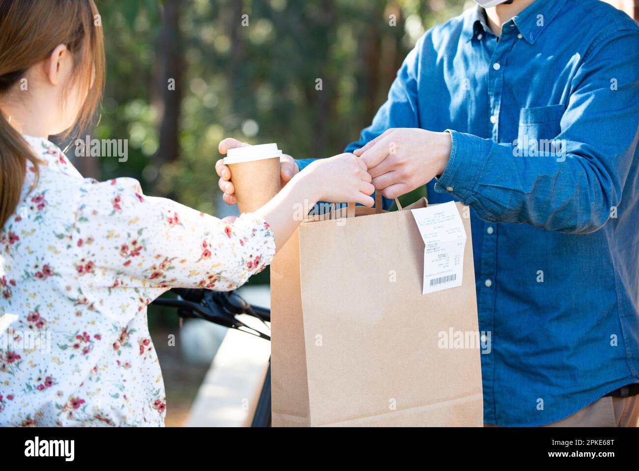 Man and woman receiving and delivering food delivery items Stock Photo ...