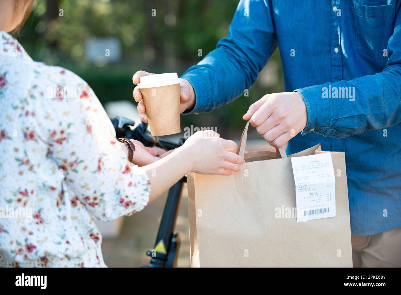 Man and woman handing over food delivery items Stock Photo - Alamy
