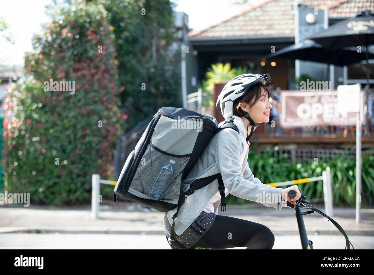 Food delivery woman on a bicycle Stock Photo - Alamy