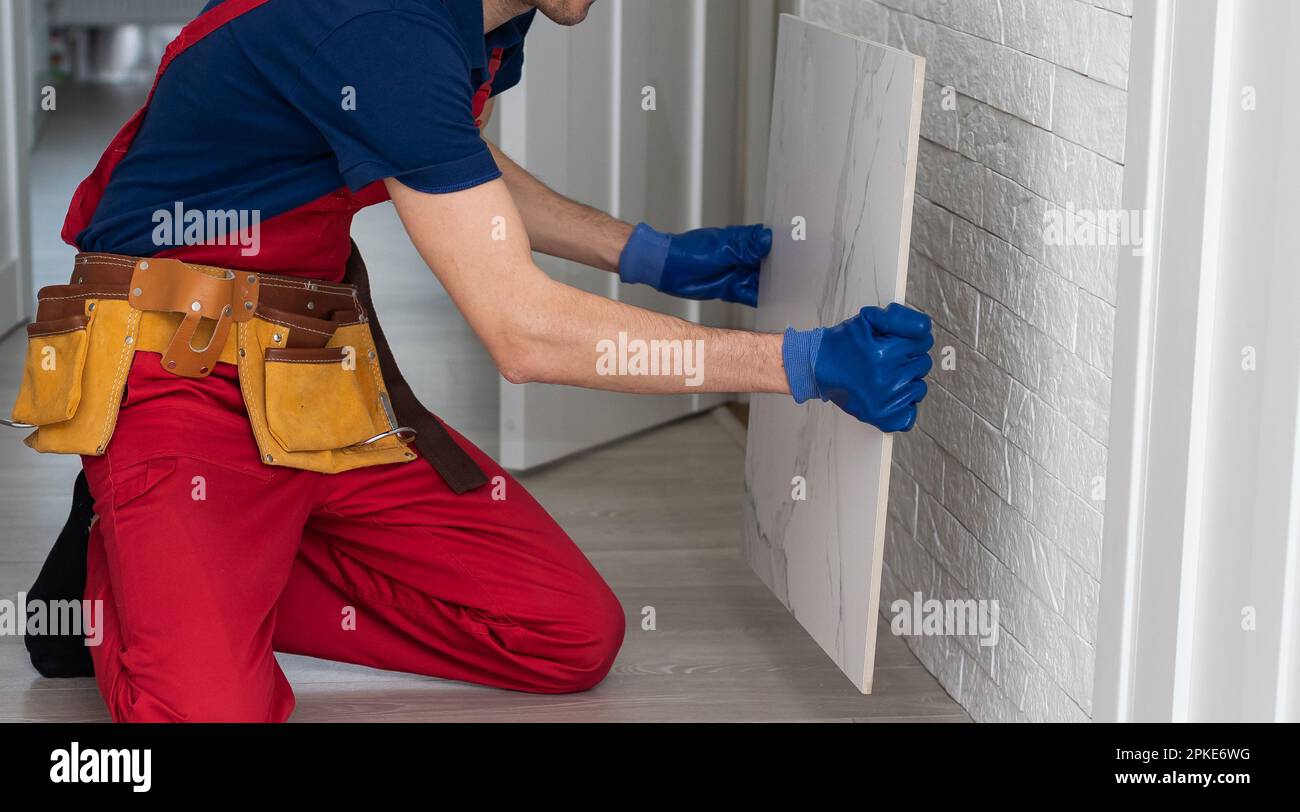 Master is wearing work clothes, is checking horizon of installing tiles ...