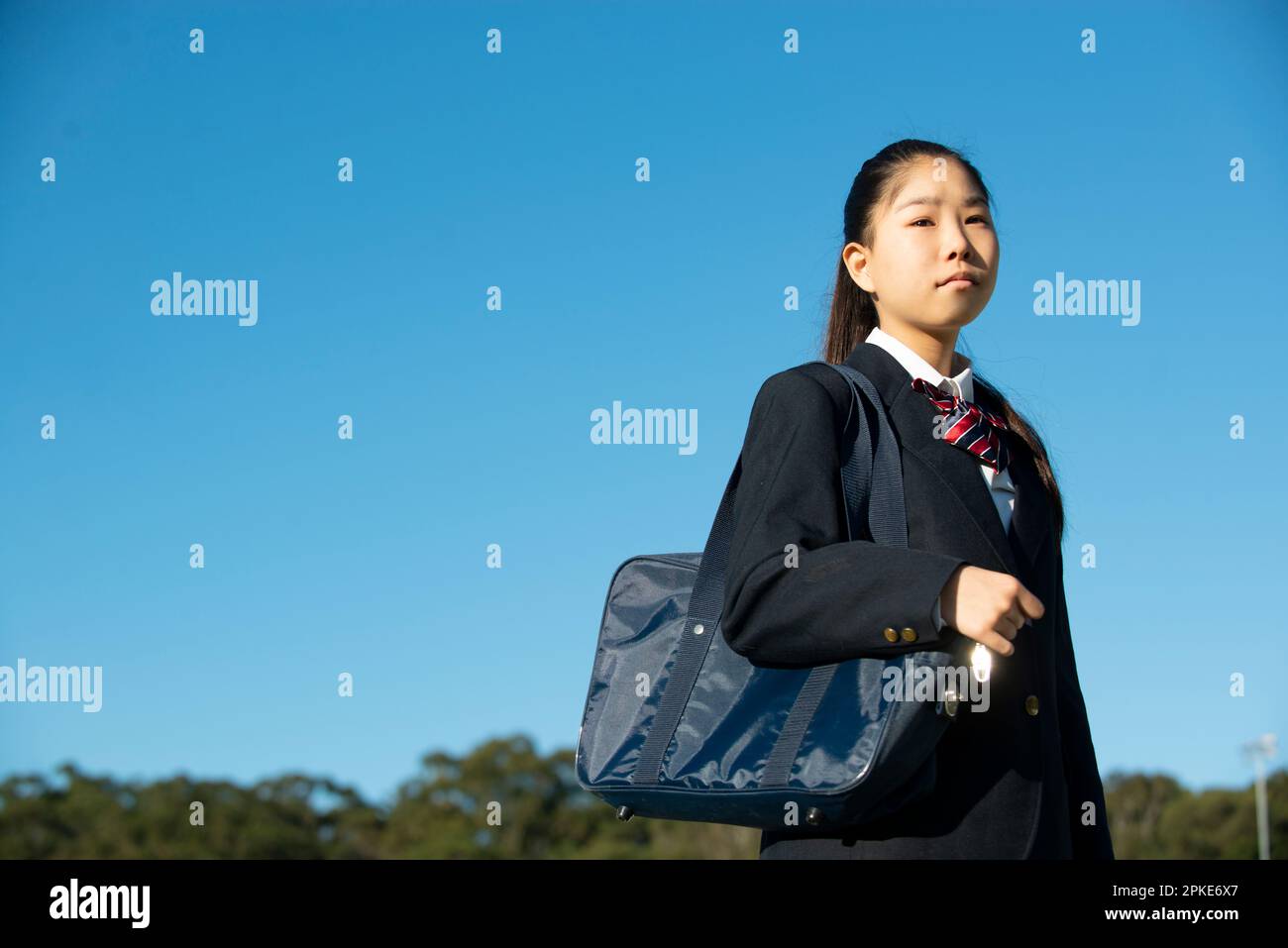 Female student in school uniform looking into the distance Stock Photo ...