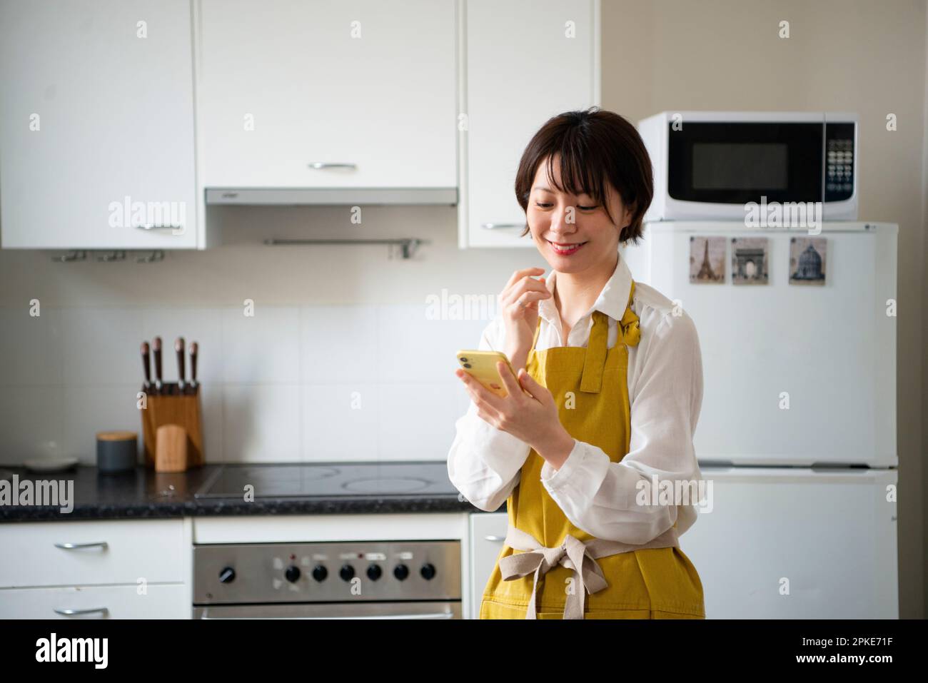 Woman searching for a recipe on her phone Stock Photo - Alamy
