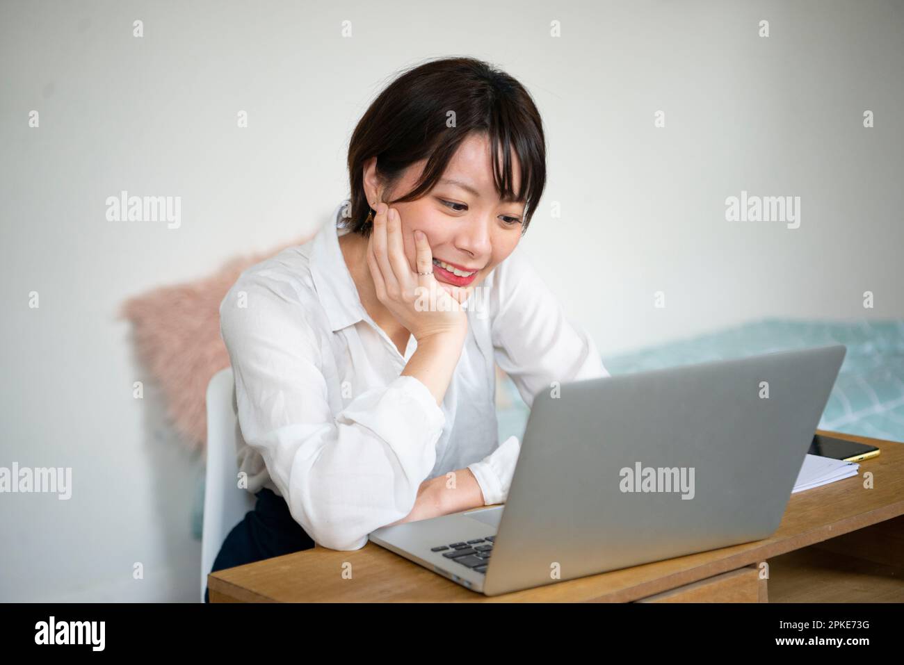 Woman laughing in front of computer Stock Photo - Alamy