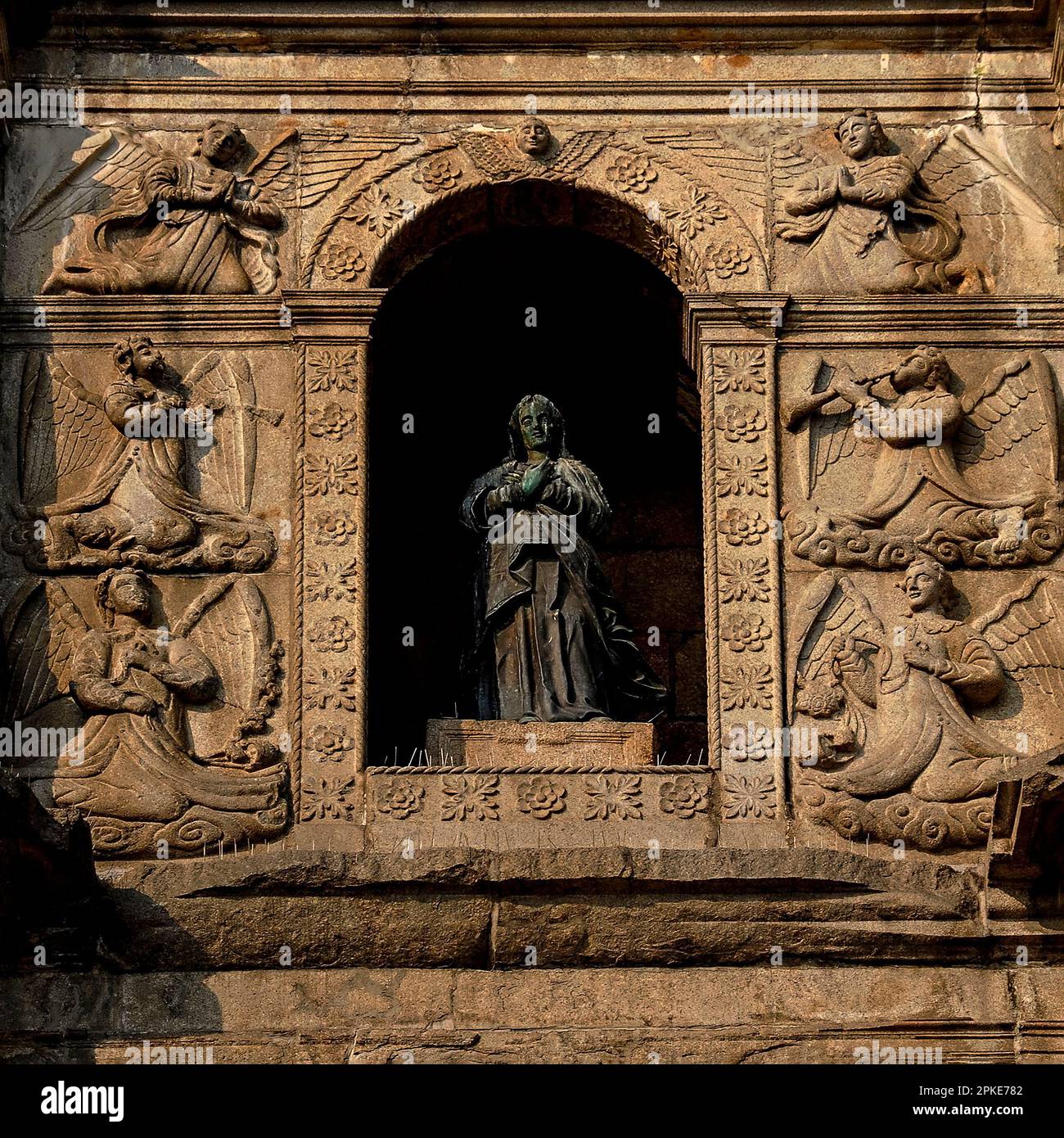 Angels praying, blowing horns and swinging incense censers flank a ...
