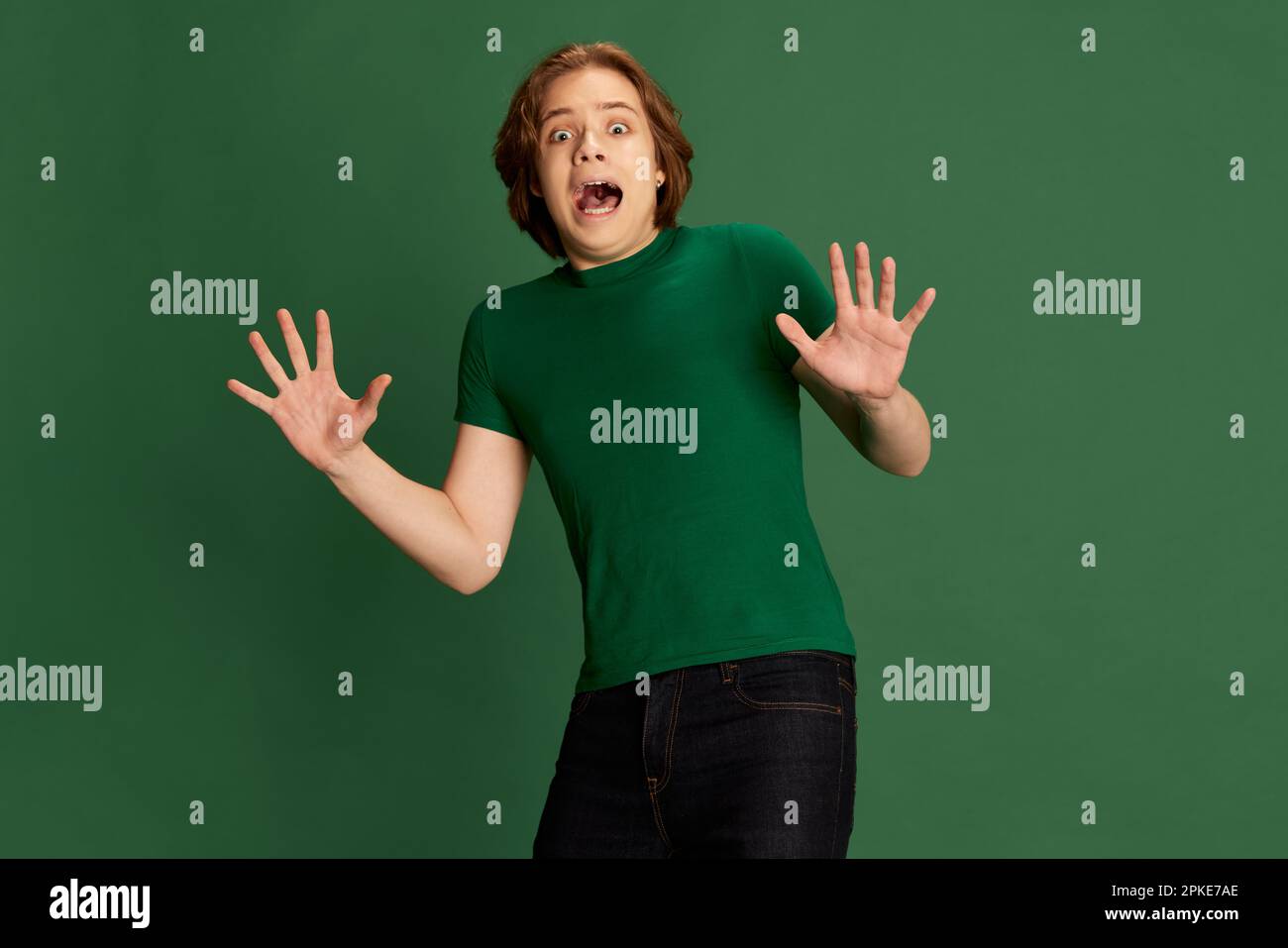 Portrait with young frightened man , guy screaming and raising hands ...