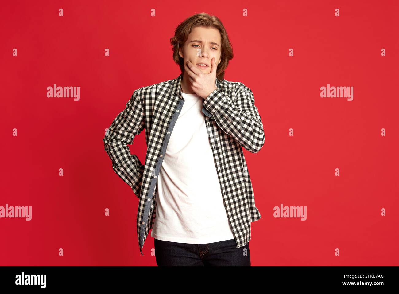 One pensive man standing with folded hands and thinking with sad facial ...