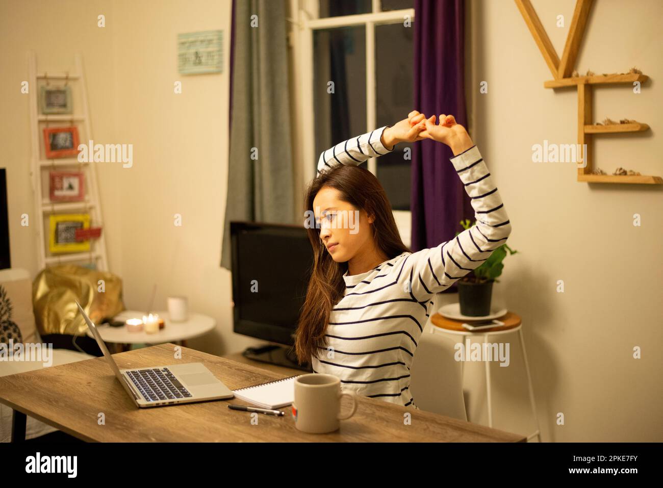 Woman stretching in front of computer Stock Photo - Alamy