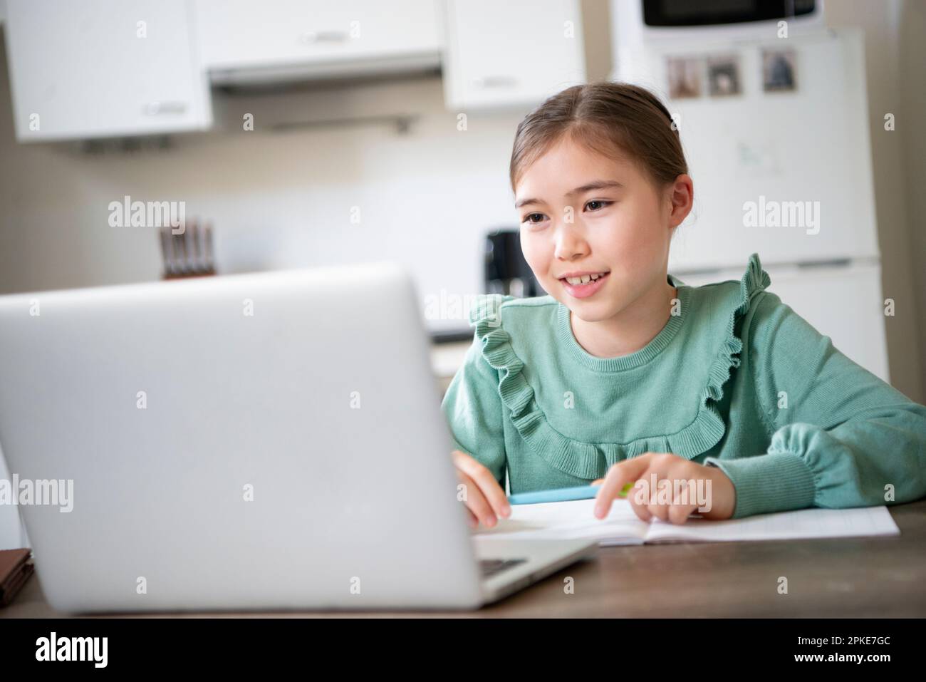 Girl taking a class at home using computer Stock Photo - Alamy