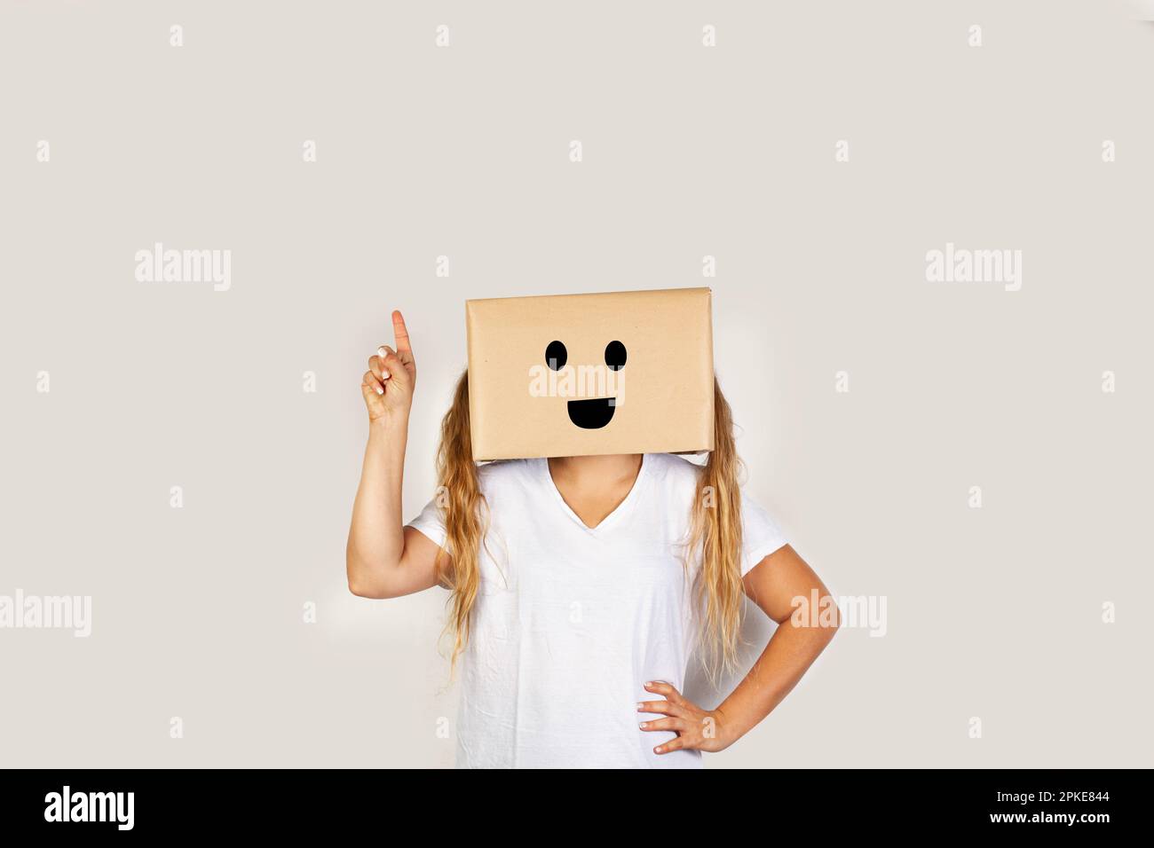 Woman with her head in a box and happiness gesture drawn on it with ...