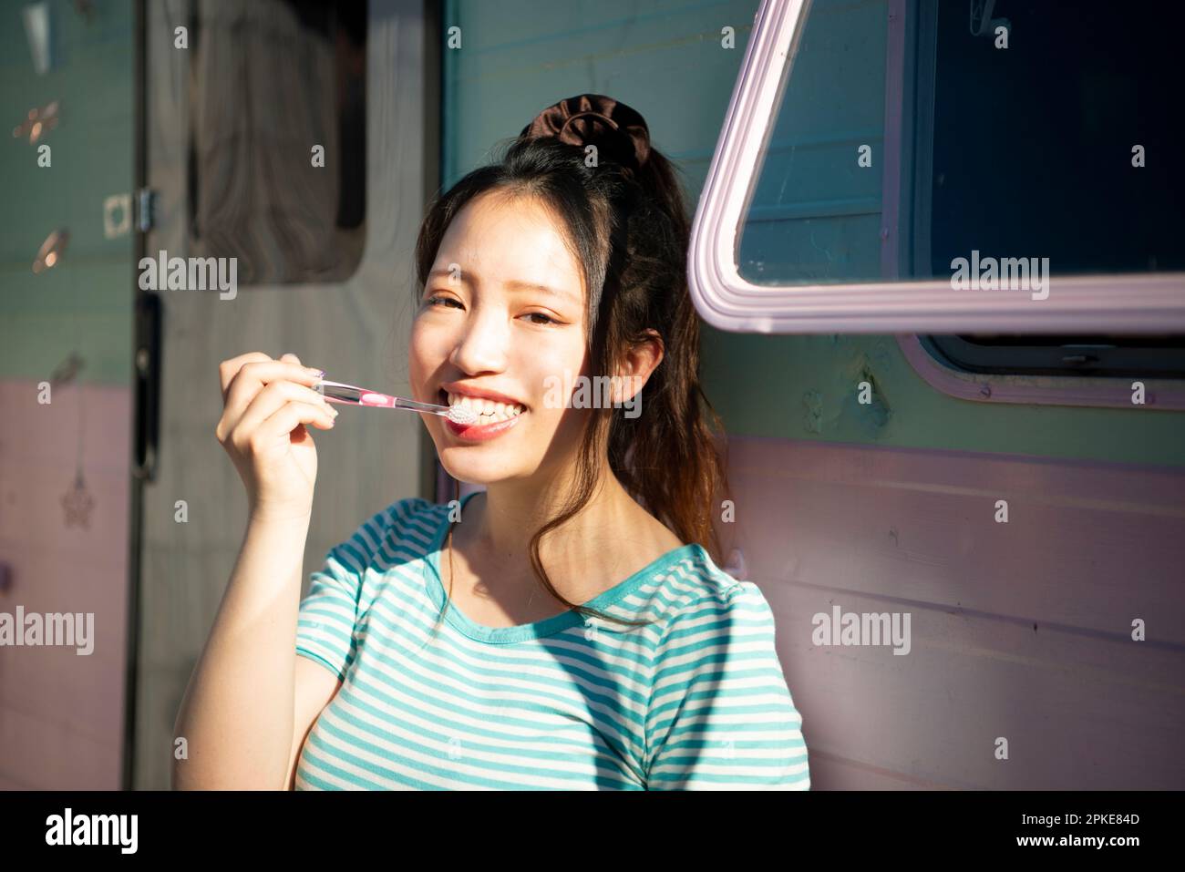 Woman brushing her teeth outside Stock Photo - Alamy