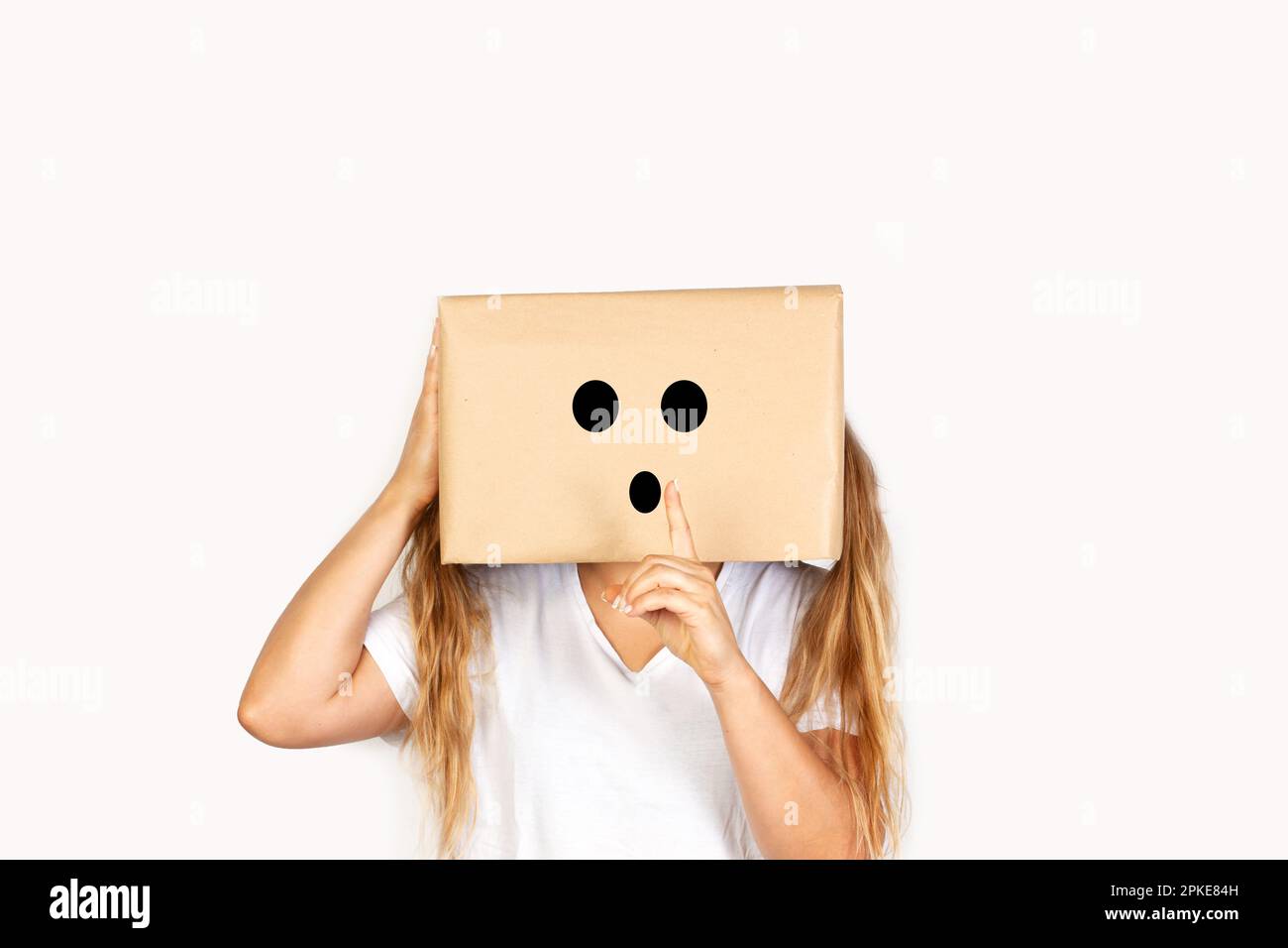 Woman with her head in a box and amazement gesture on a white ...