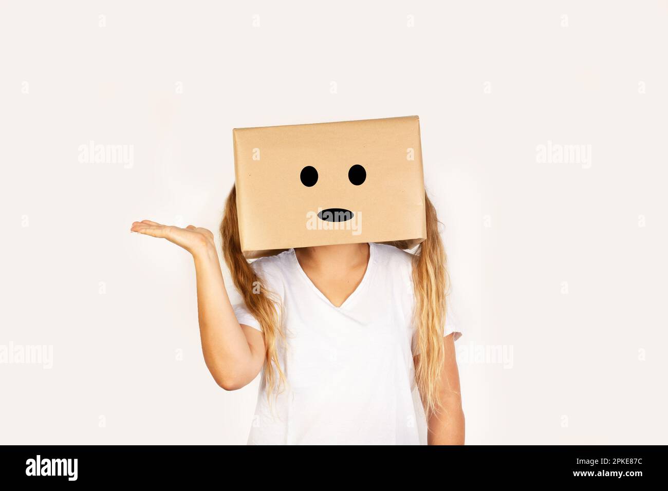 Woman with her head in a box and gesture of what happens standing on a ...