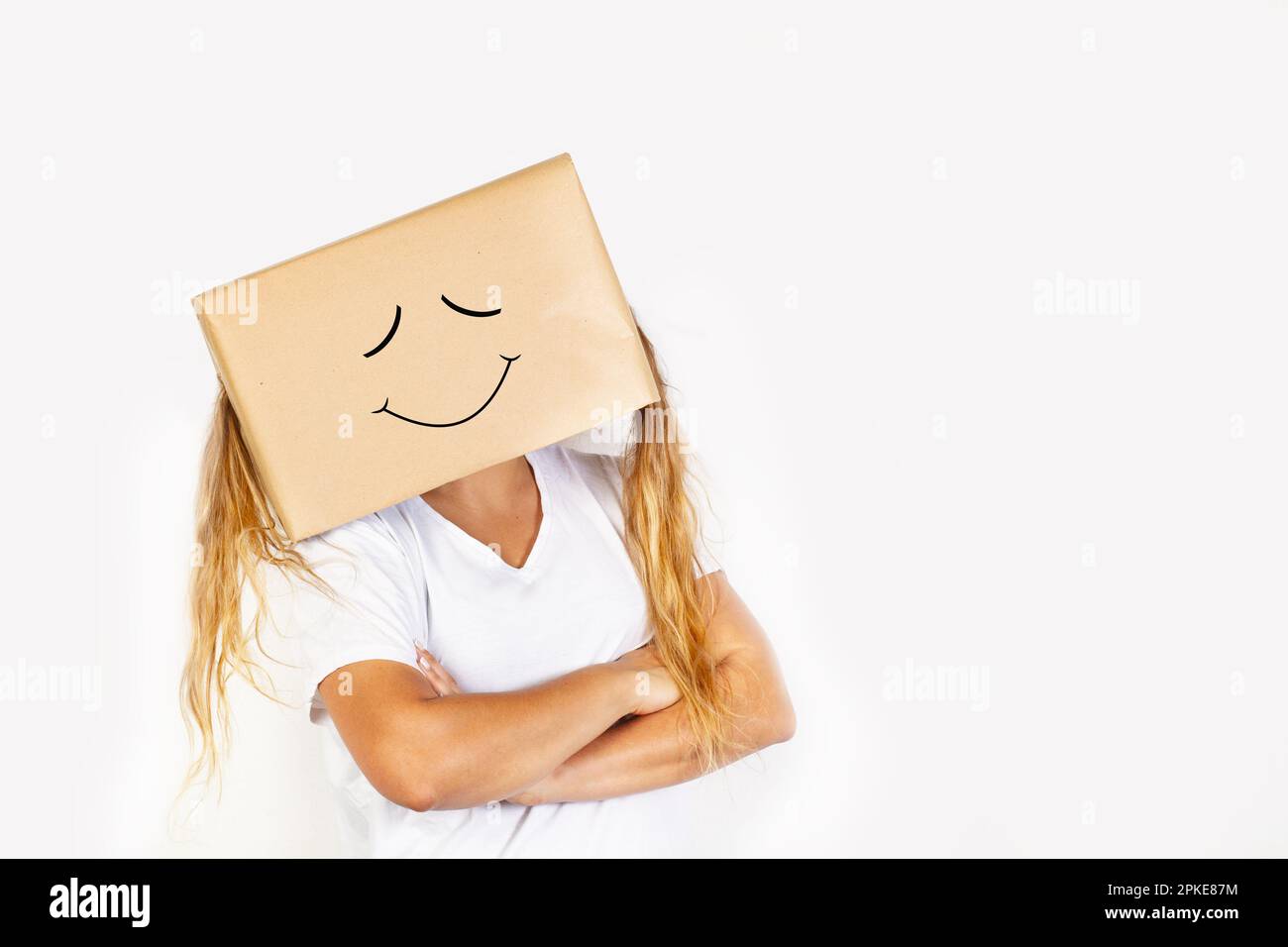 Woman with her head in a box and happiness gesture drawn on it with arm ...