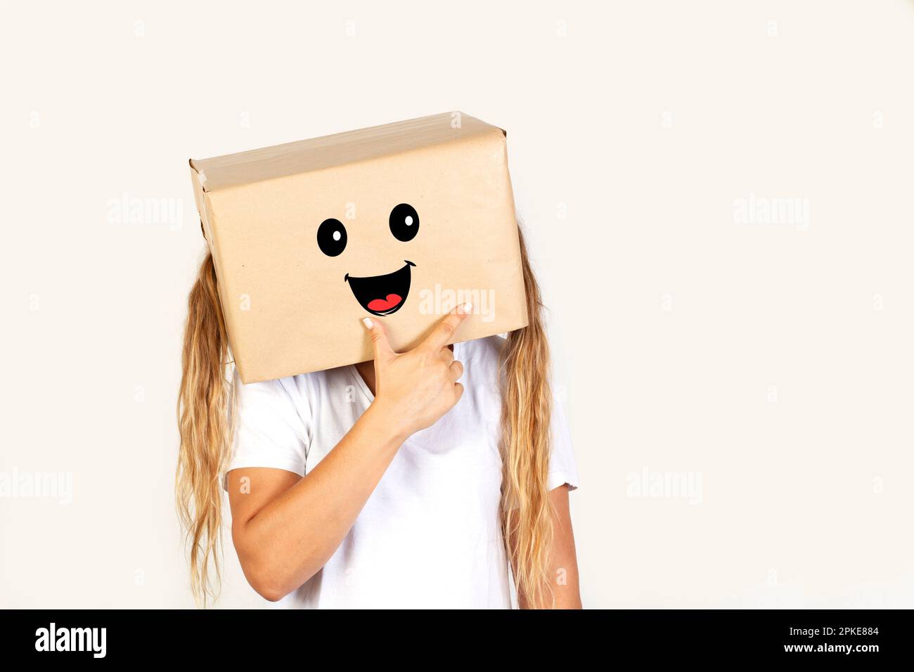 Woman with her head in a box and happiness gesture standing on a white ...