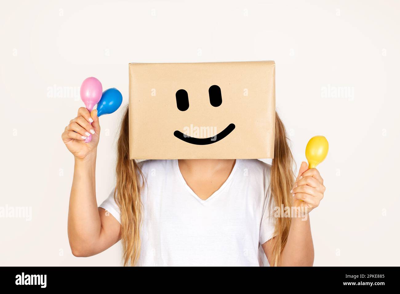 Woman with her head in a box and smile gesture holding plastic colored ...
