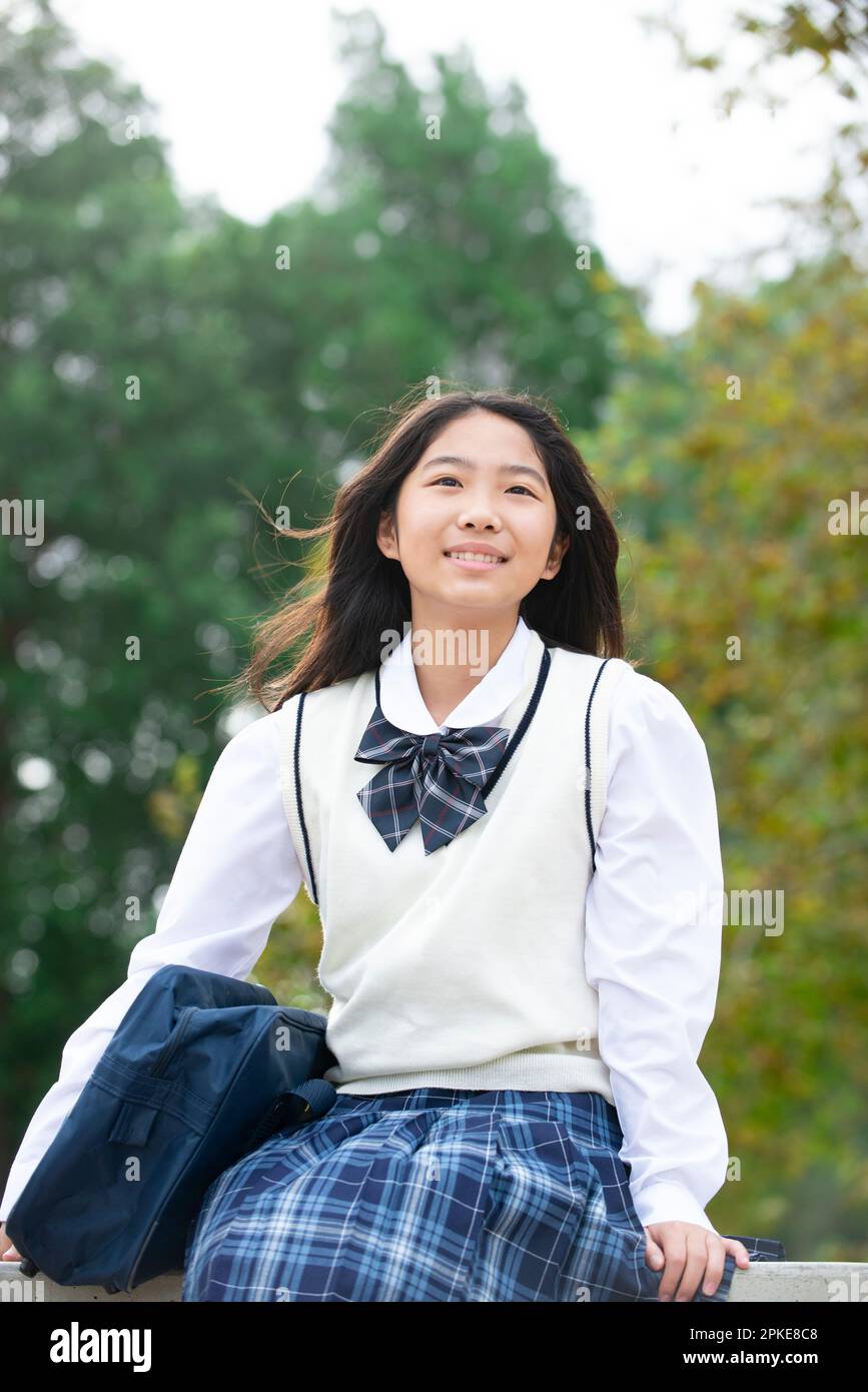 Female student sitting outside looking up Stock Photo - Alamy