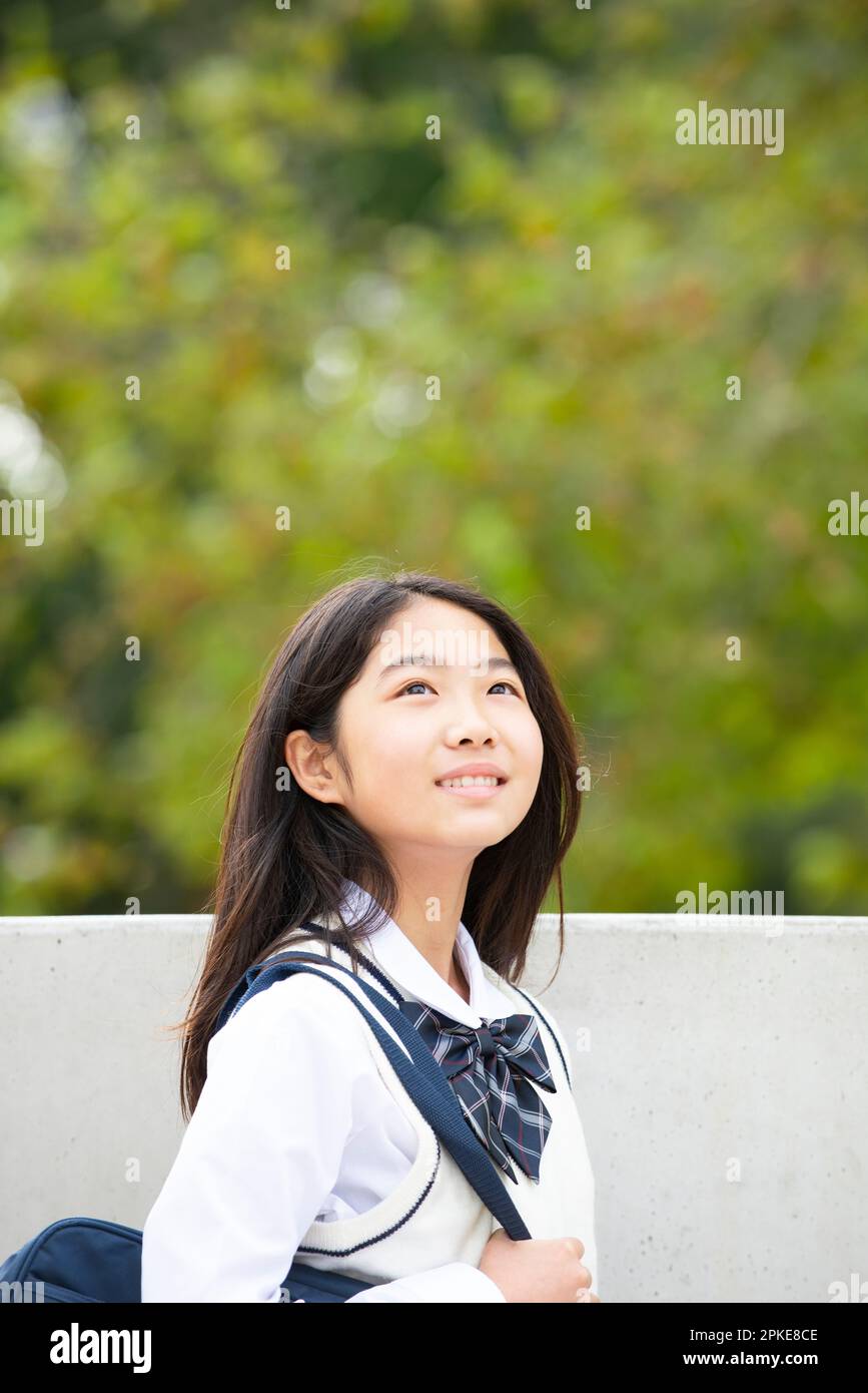 Female student looking up at green background Stock Photo - Alamy