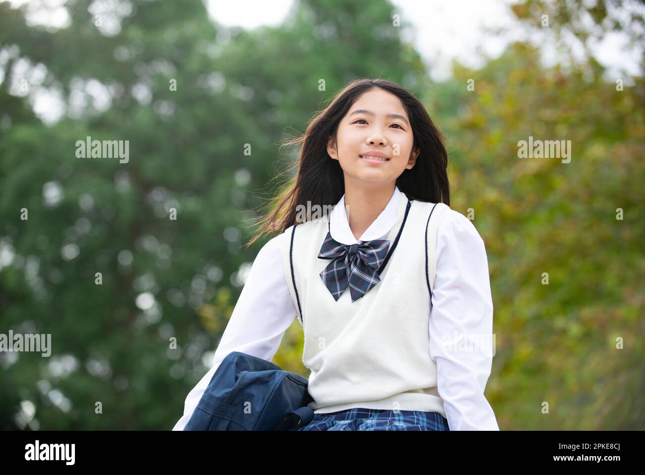 Female student sitting outside looking up Stock Photo - Alamy