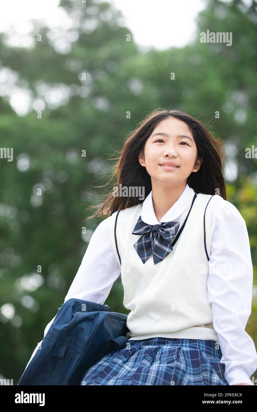 Female student sitting outside looking up Stock Photo - Alamy