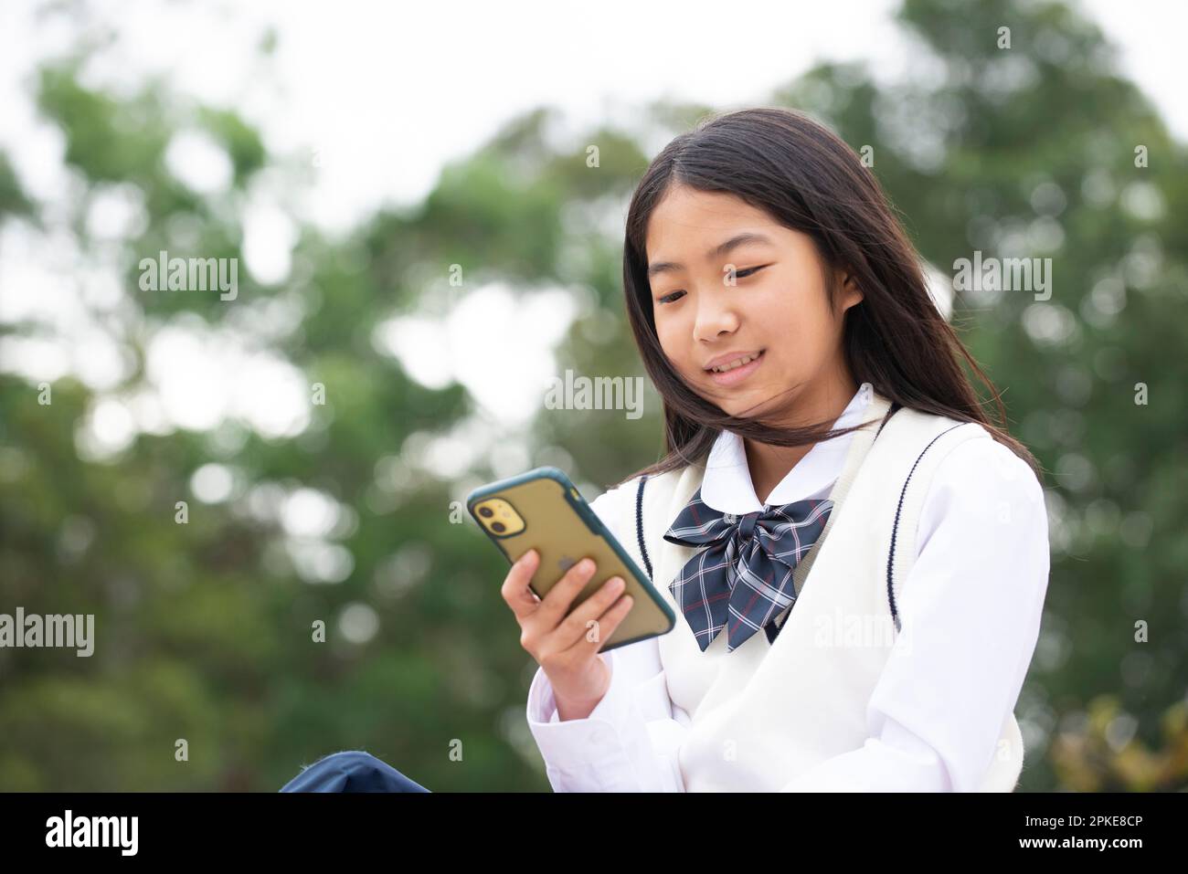 Female student in school uniform looking at her phone Stock Photo - Alamy