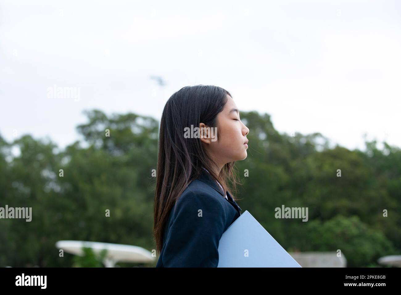 Side view of a female student in school uniform with her eyes closed ...