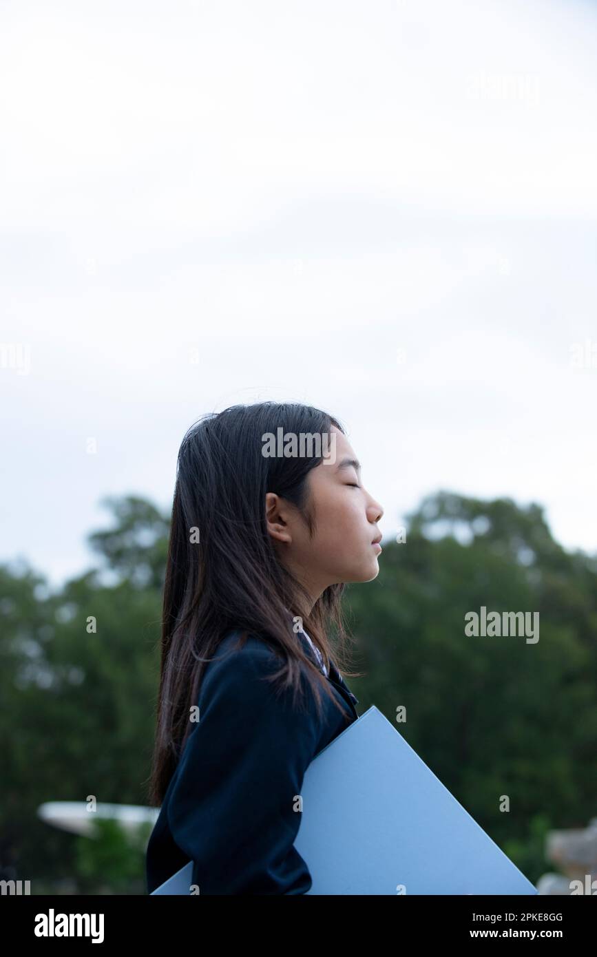 Side view of a female student in school uniform with her eyes closed ...