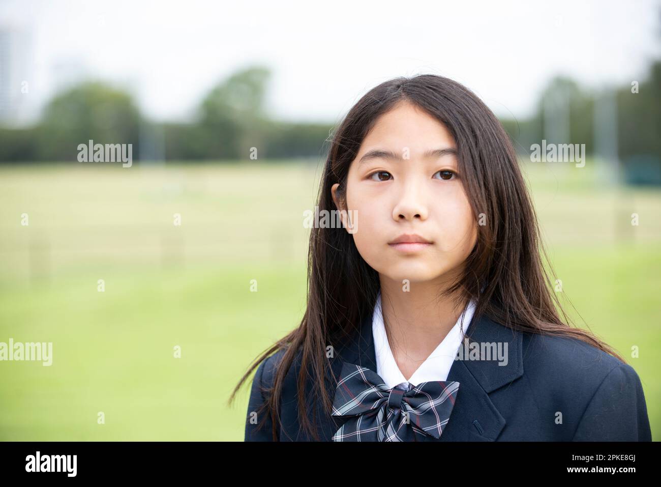 Female student in school uniform looking into the distance Stock Photo ...
