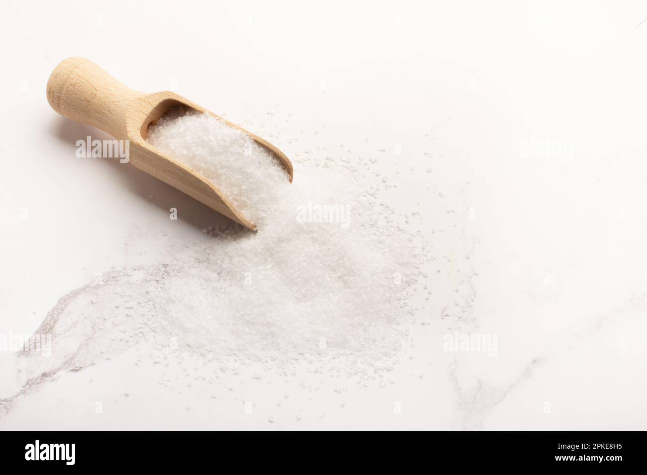 Salt in flakes in a wooden spoon and on a marble kitchen counter Stock ...