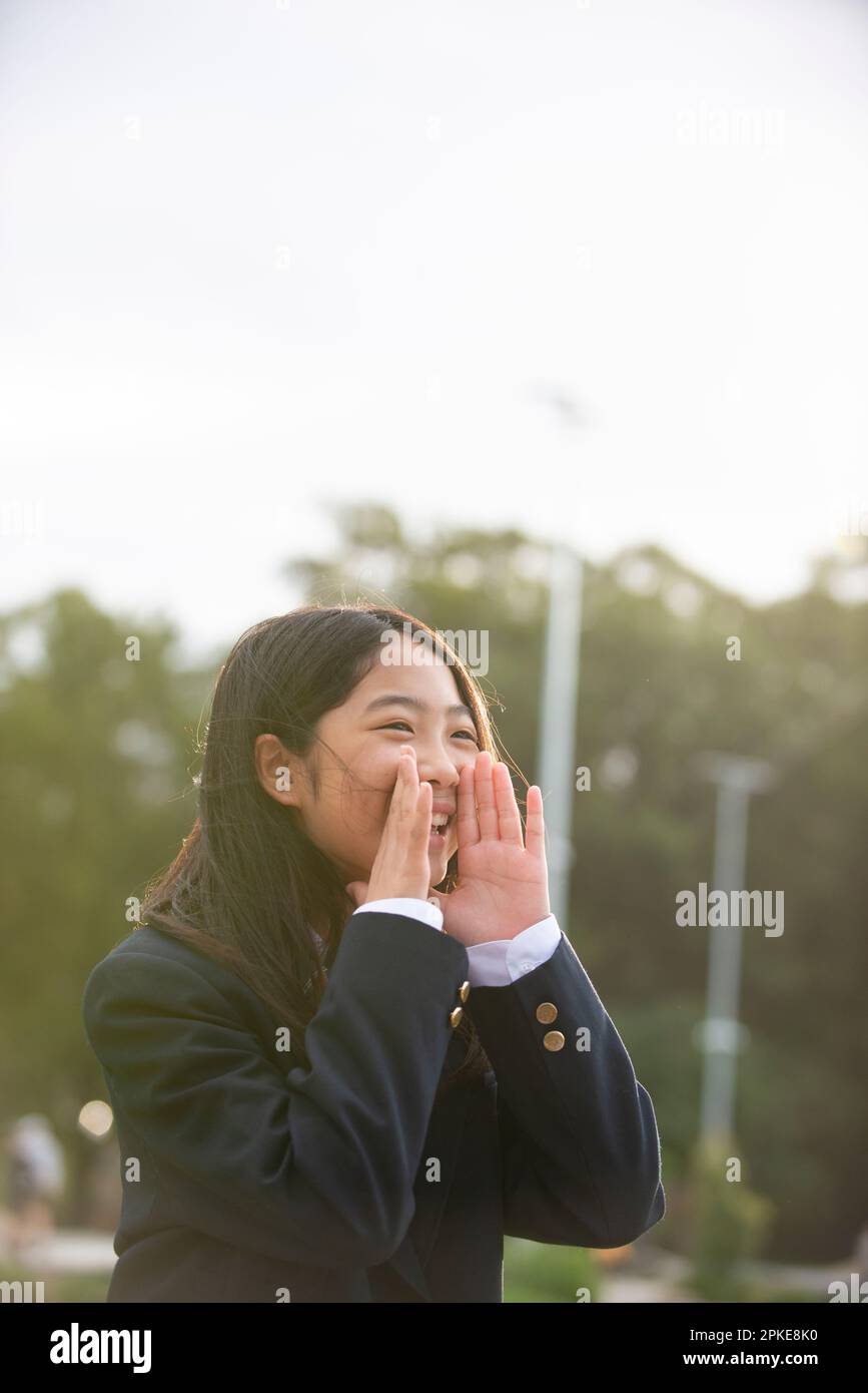 A female student in uniform holding her hand and shouting Stock Photo ...