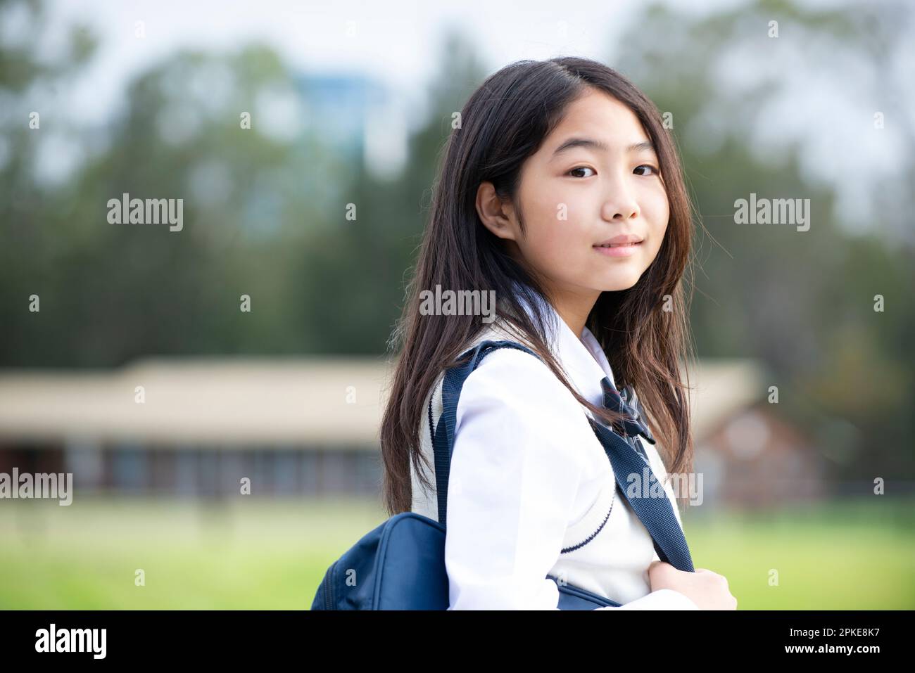 Female student in uniform looking back and smiling Stock Photo - Alamy