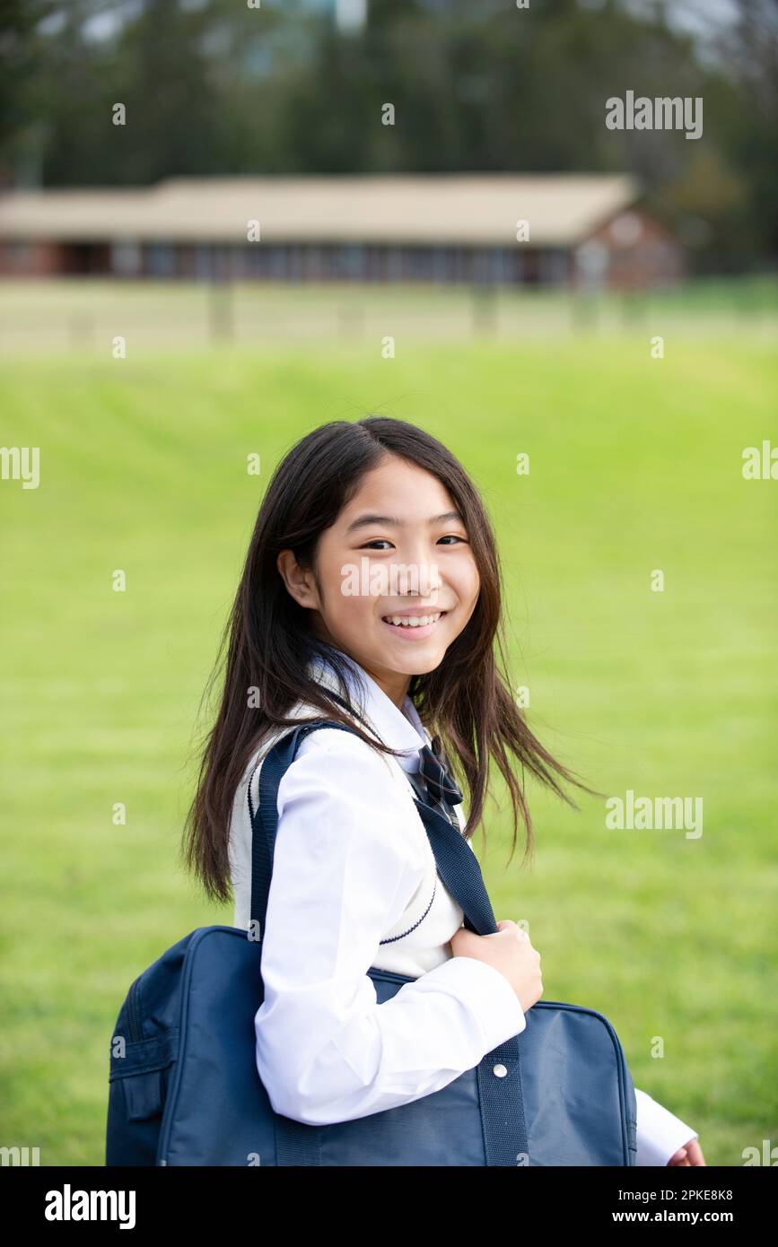 Female student in school uniform looking back and smiling Stock Photo ...