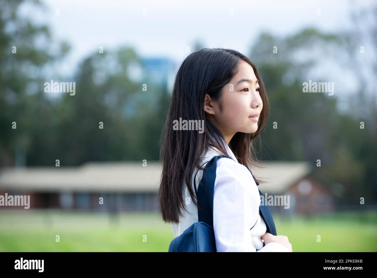 Profile of a female student in school uniform looking into the distance ...