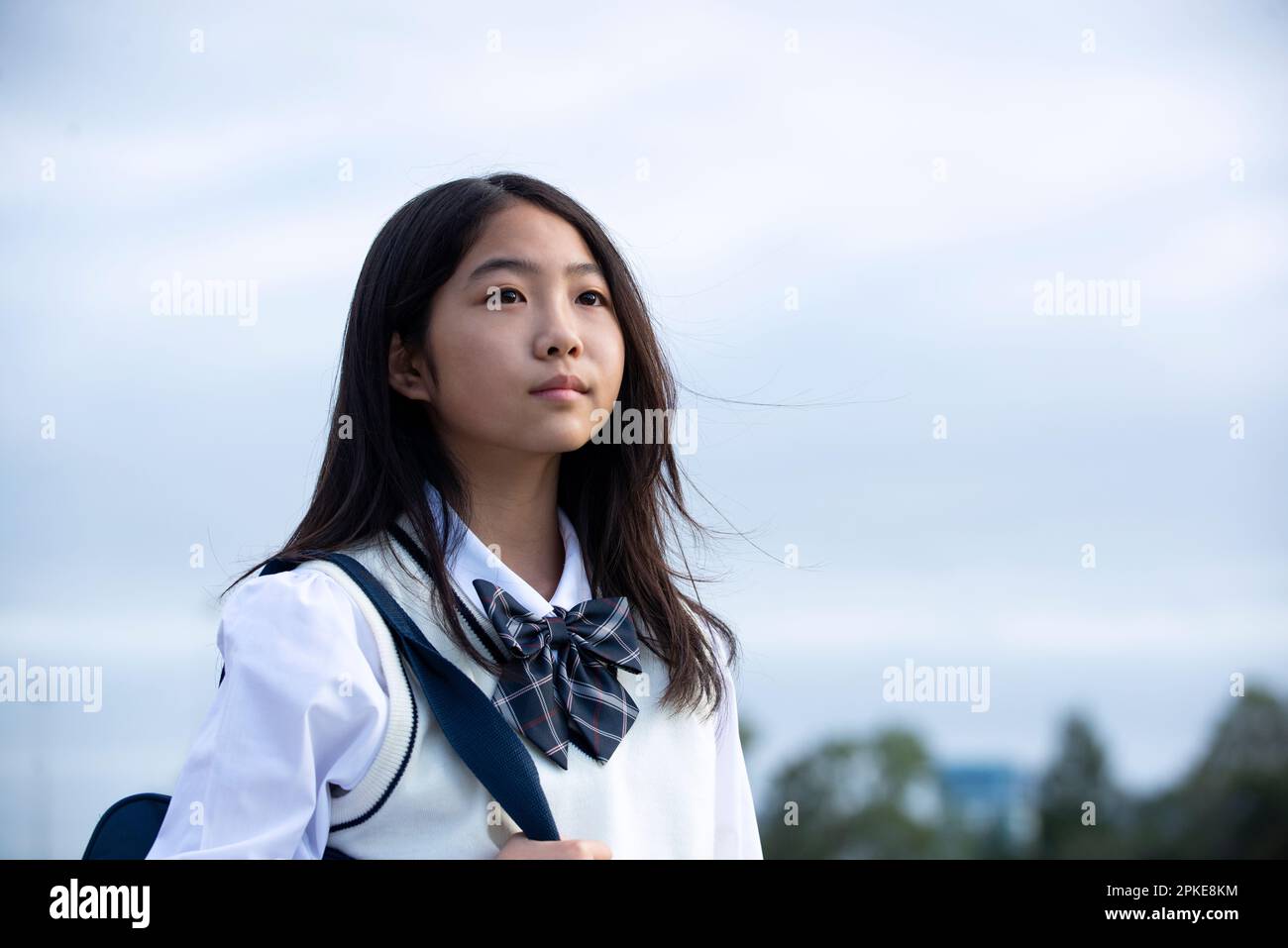 Female student in school uniform looking into the distance Stock Photo ...