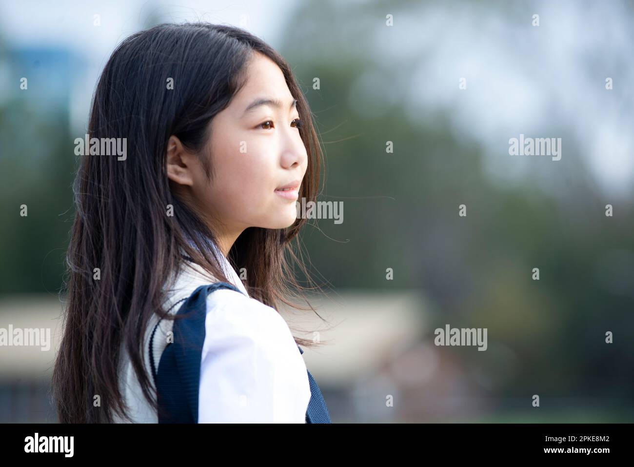 Profile of a female student in school uniform looking into the distance ...