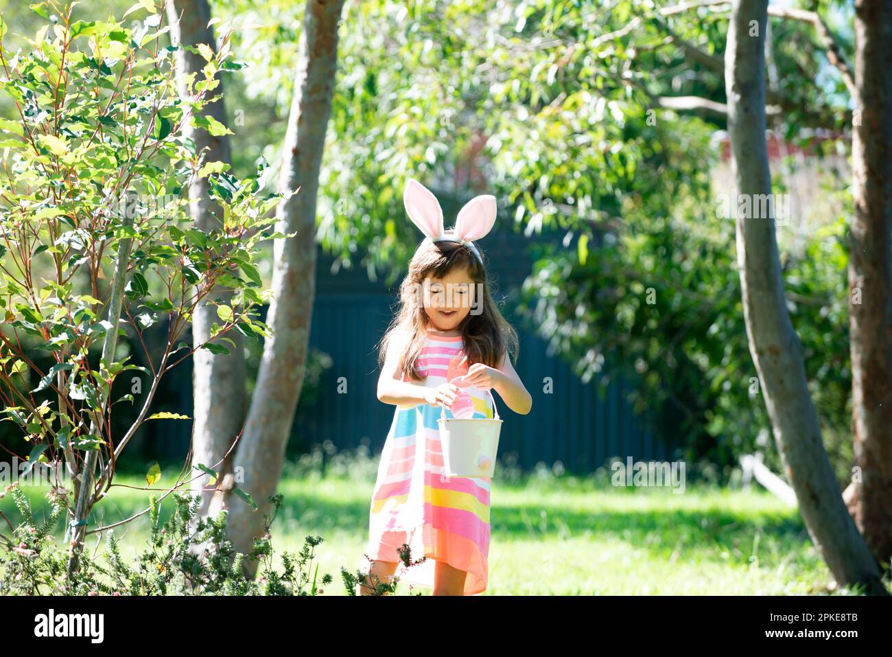 Girl doing Easter egg hunt Stock Photo - Alamy