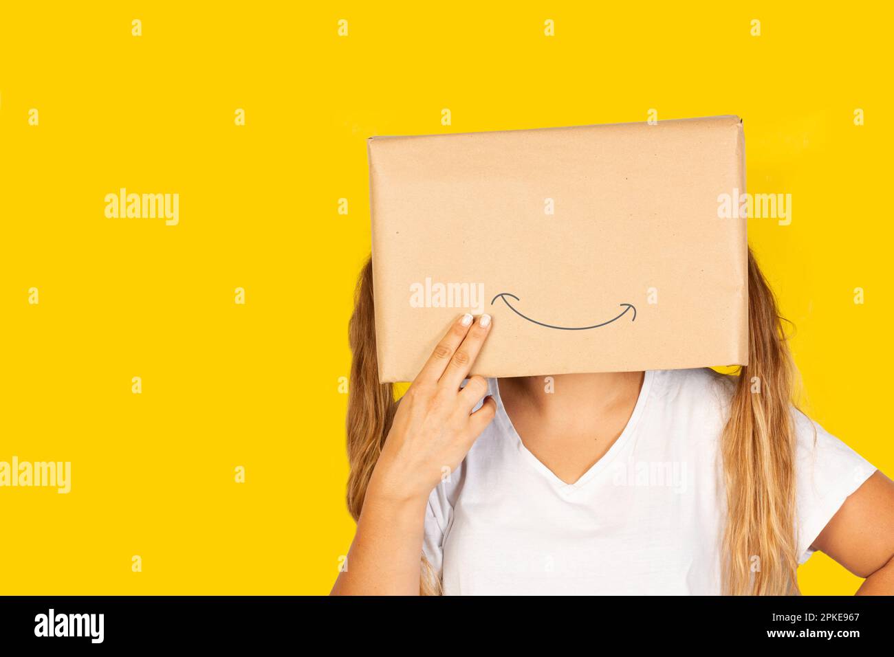 Woman with her head in a box and happiness gesture drawn on it and ...