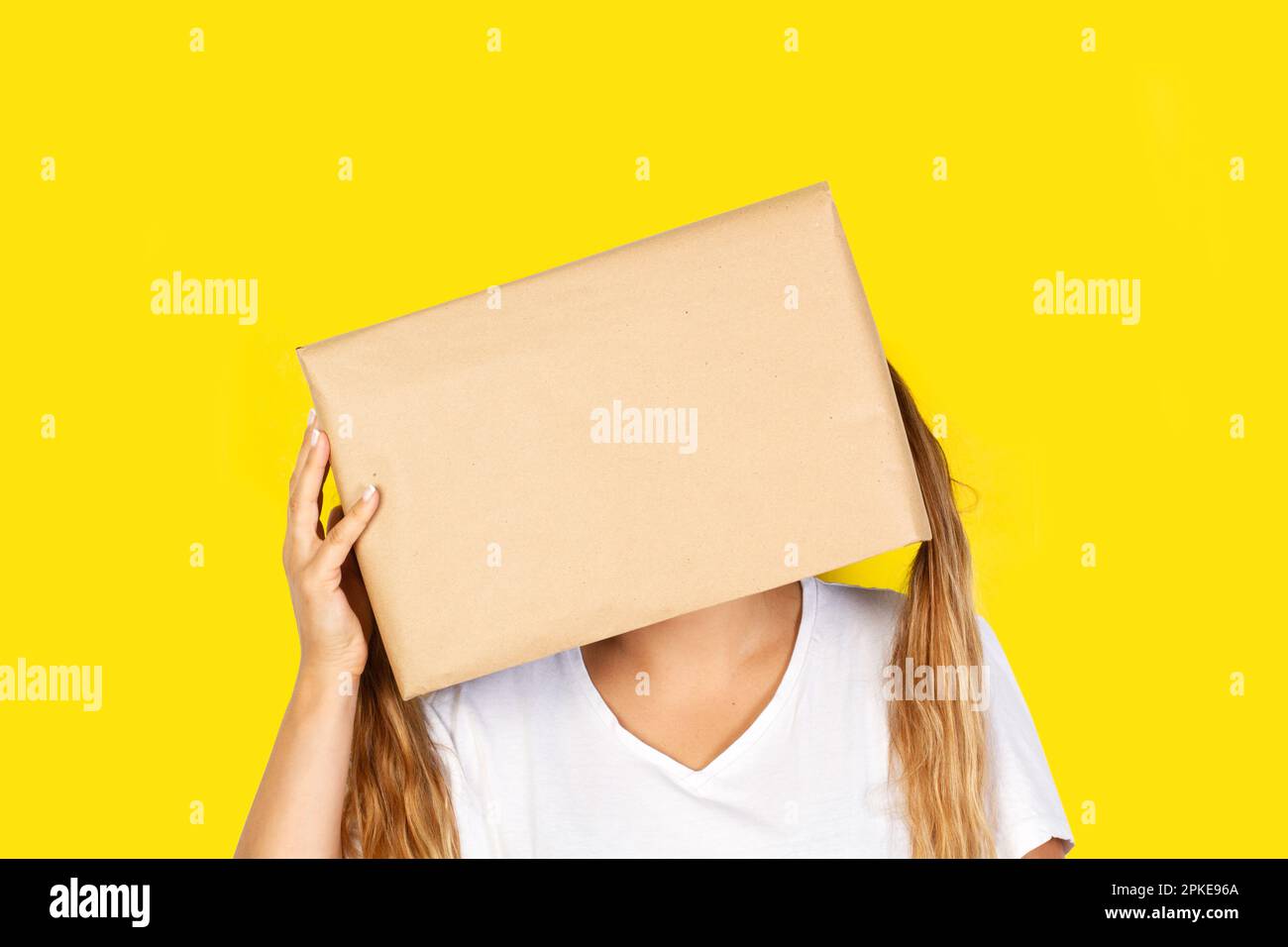 Woman with her head in a box and with his hand in a headache gesture ...