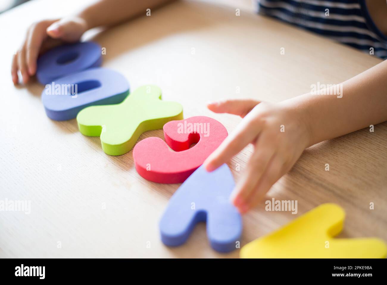 Girl playing with alphabet toys Stock Photo - Alamy